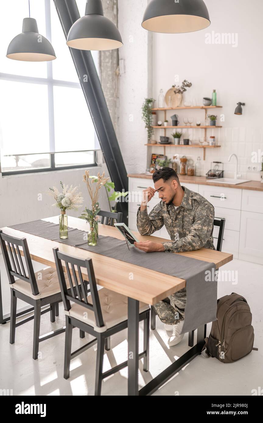 Sad young soldier staring at the photograph Stock Photo - Alamy
