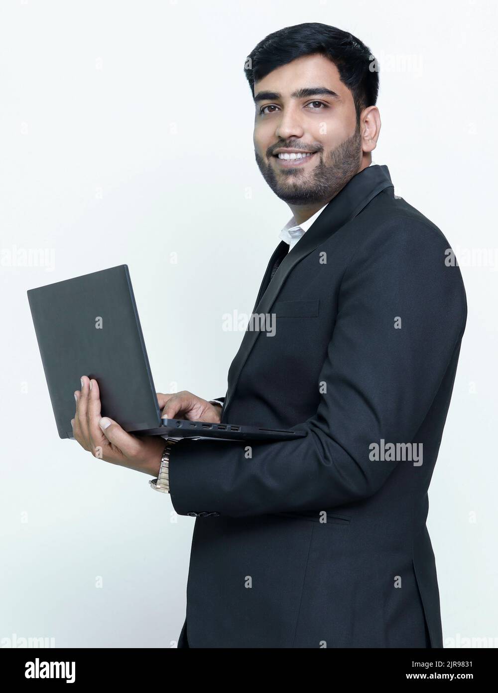Male model looking at camera with laptop in hand Stock Photo - Alamy