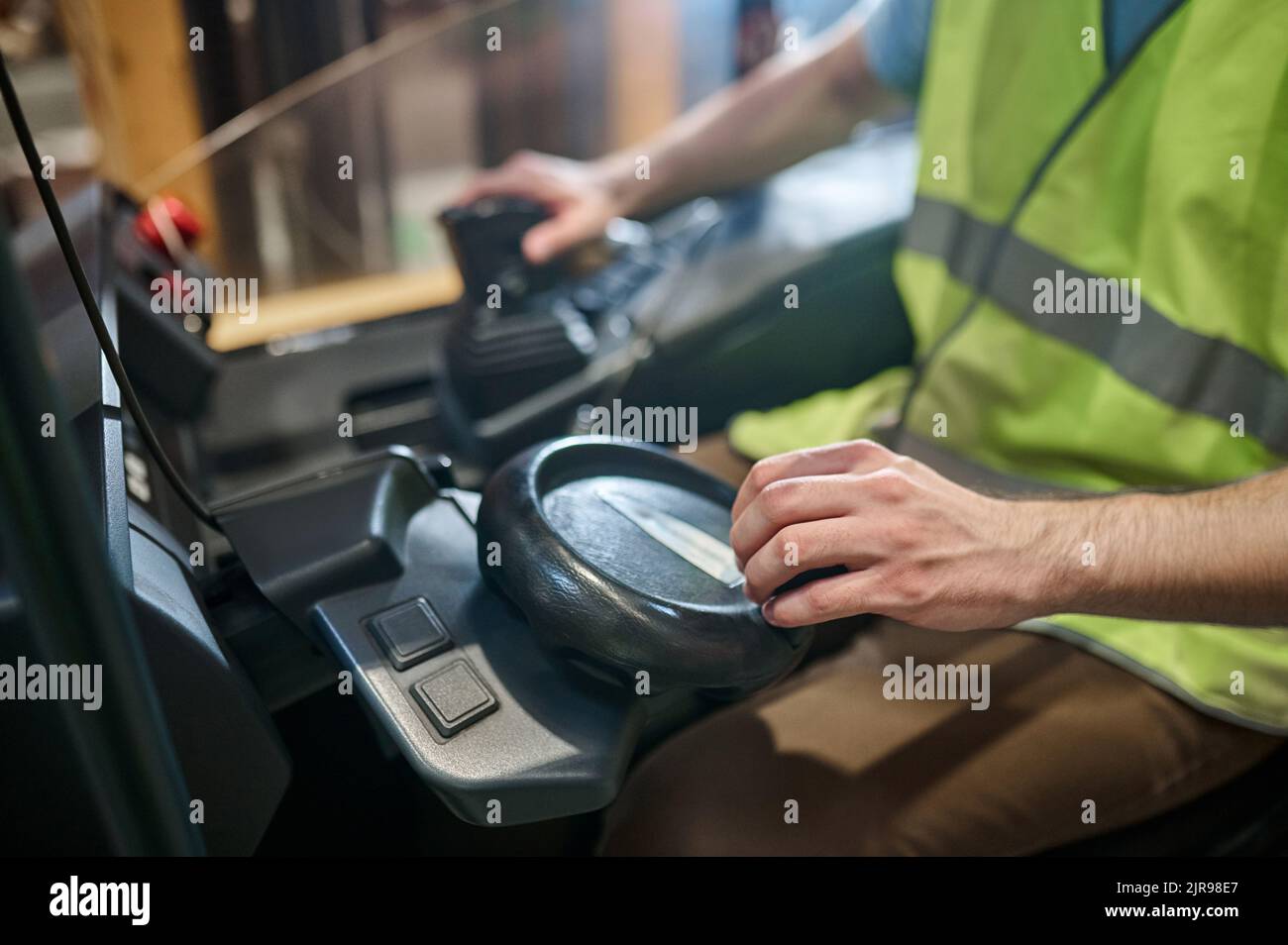 Skilled warehouse worker driving an electric forklift Stock Photo - Alamy