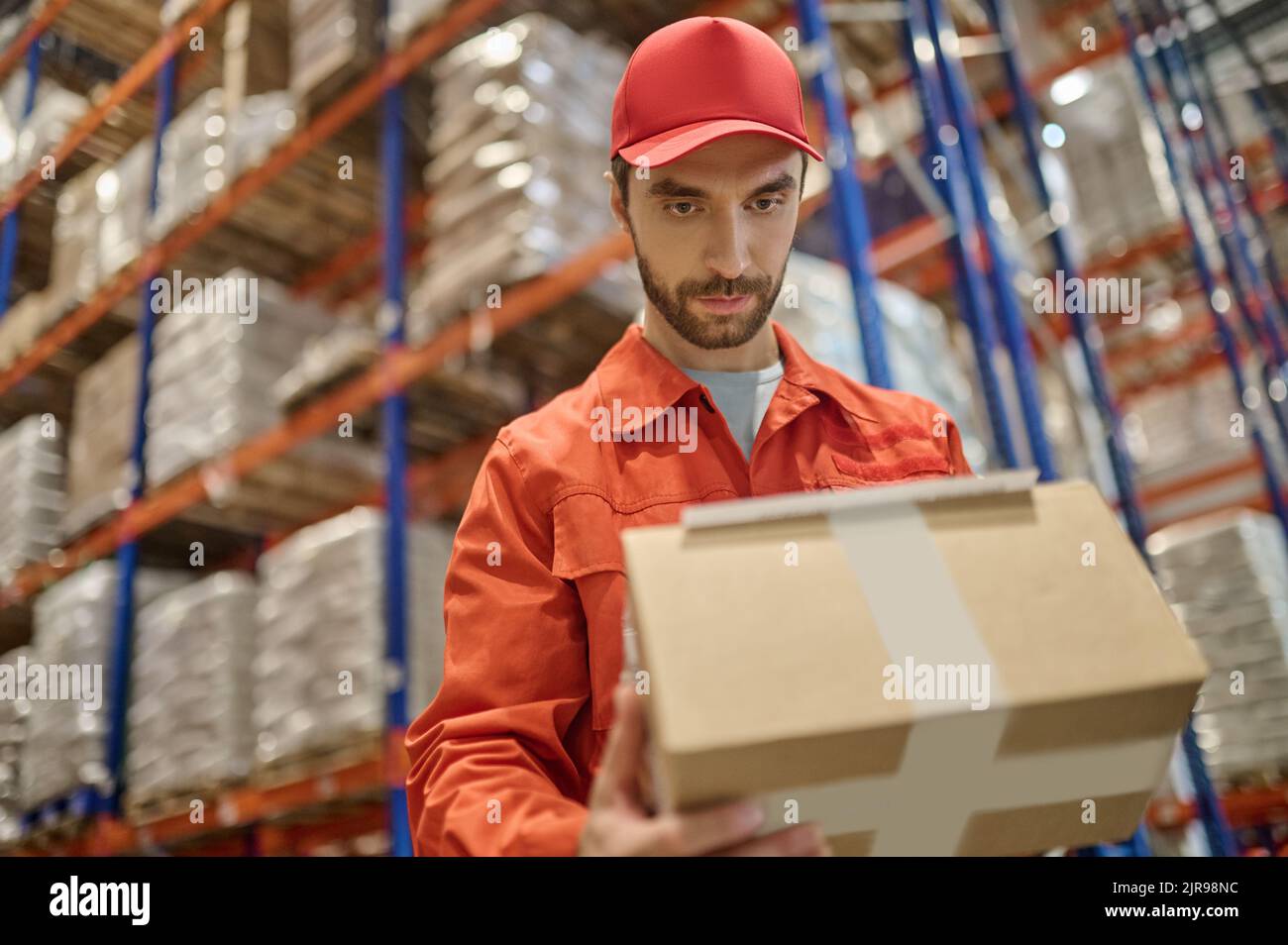 Serious young man unloading goods in the warehouse Stock Photo - Alamy