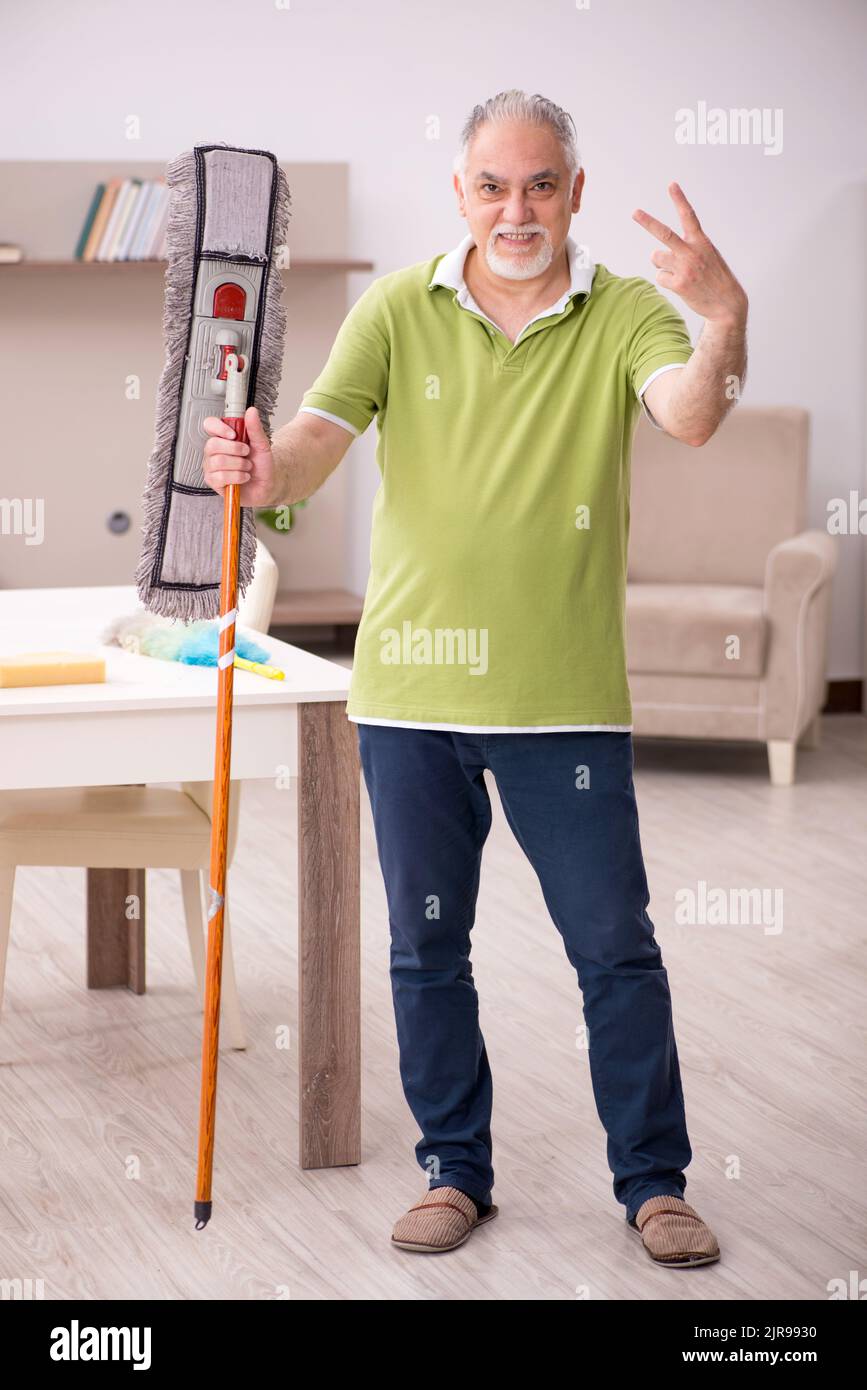 Aged man cleaning the house Stock Photo - Alamy