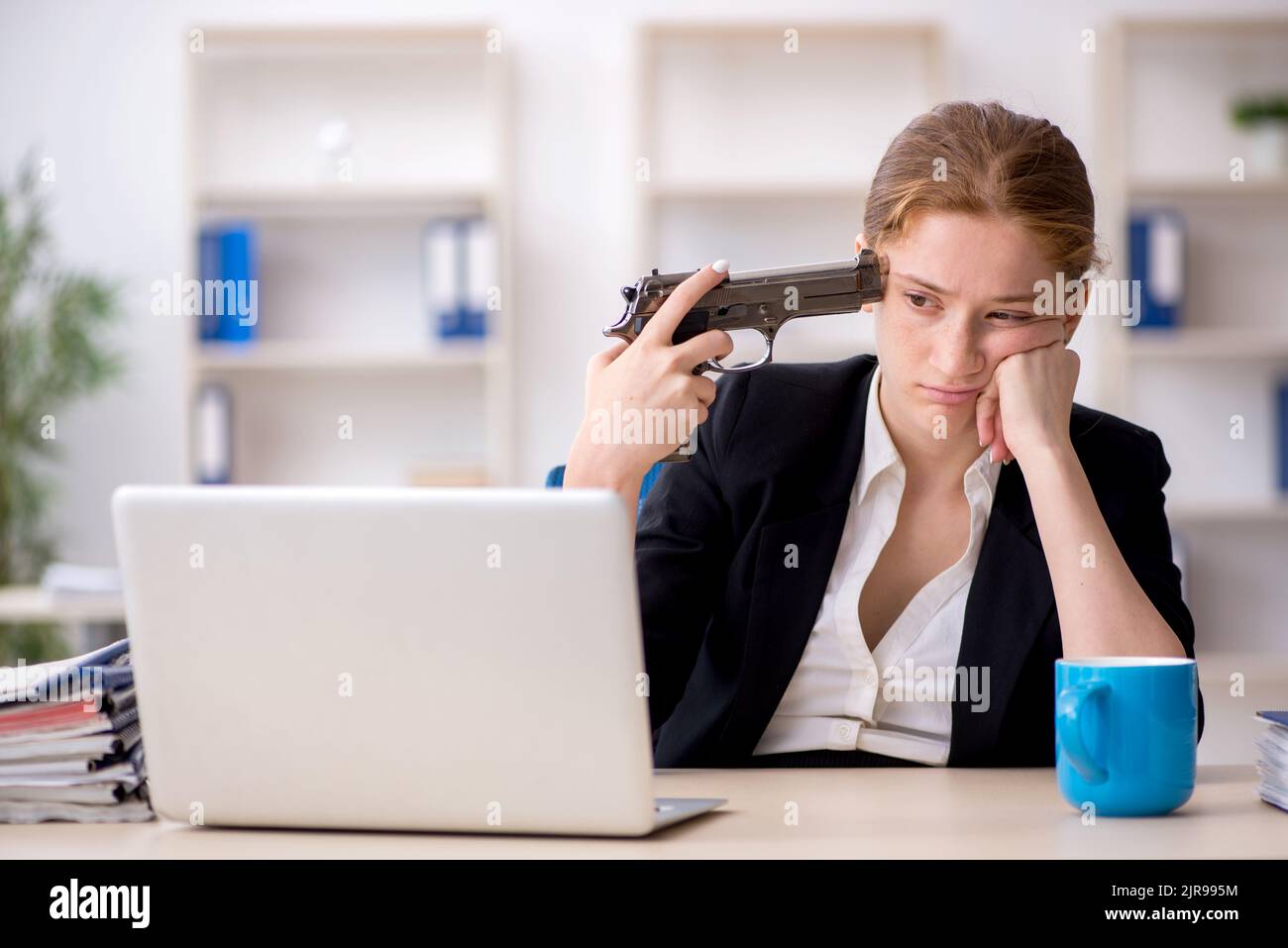 Female employee holding gun at workplace Stock Photo - Alamy