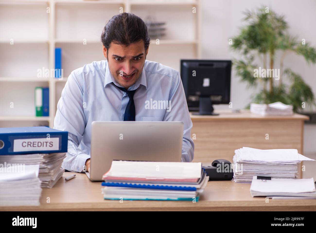 Young businessman employee and too much work in the office Stock Photo ...