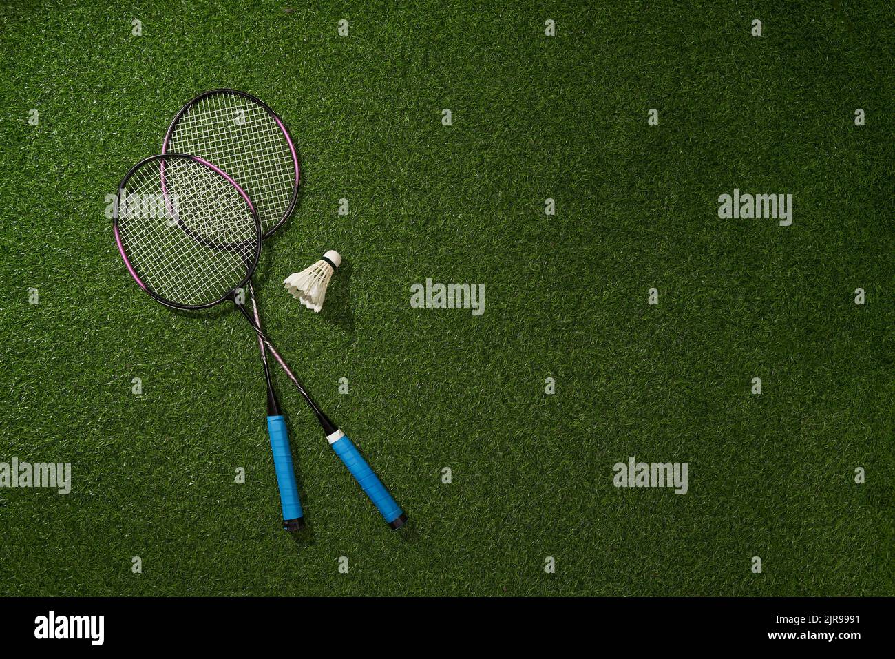 Badminton racket and shuttlecock on green grass background. Concept of ...