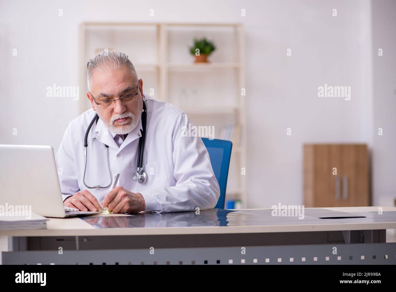 Old doctor radiologist working in the clinic Stock Photo - Alamy