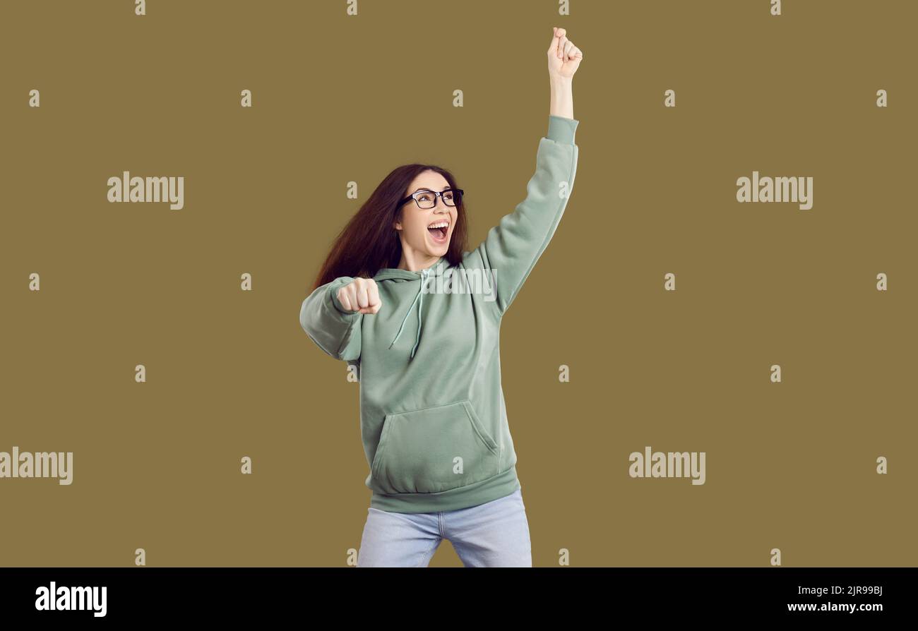 Funny happy cheerful student girl in casual clothes and glasses dancing ...