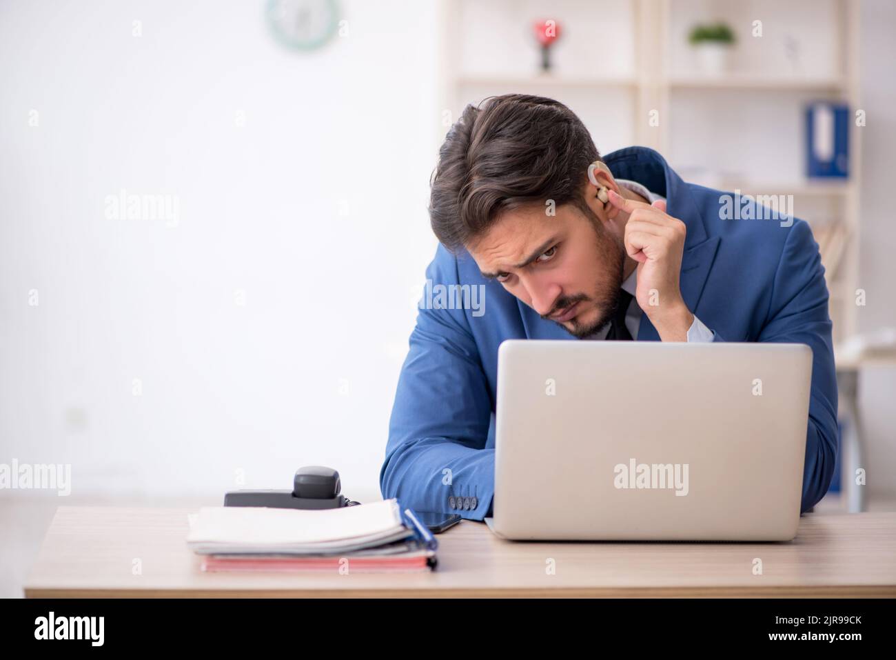 Deaf businessman employee using hearing aid in the office Stock Photo ...