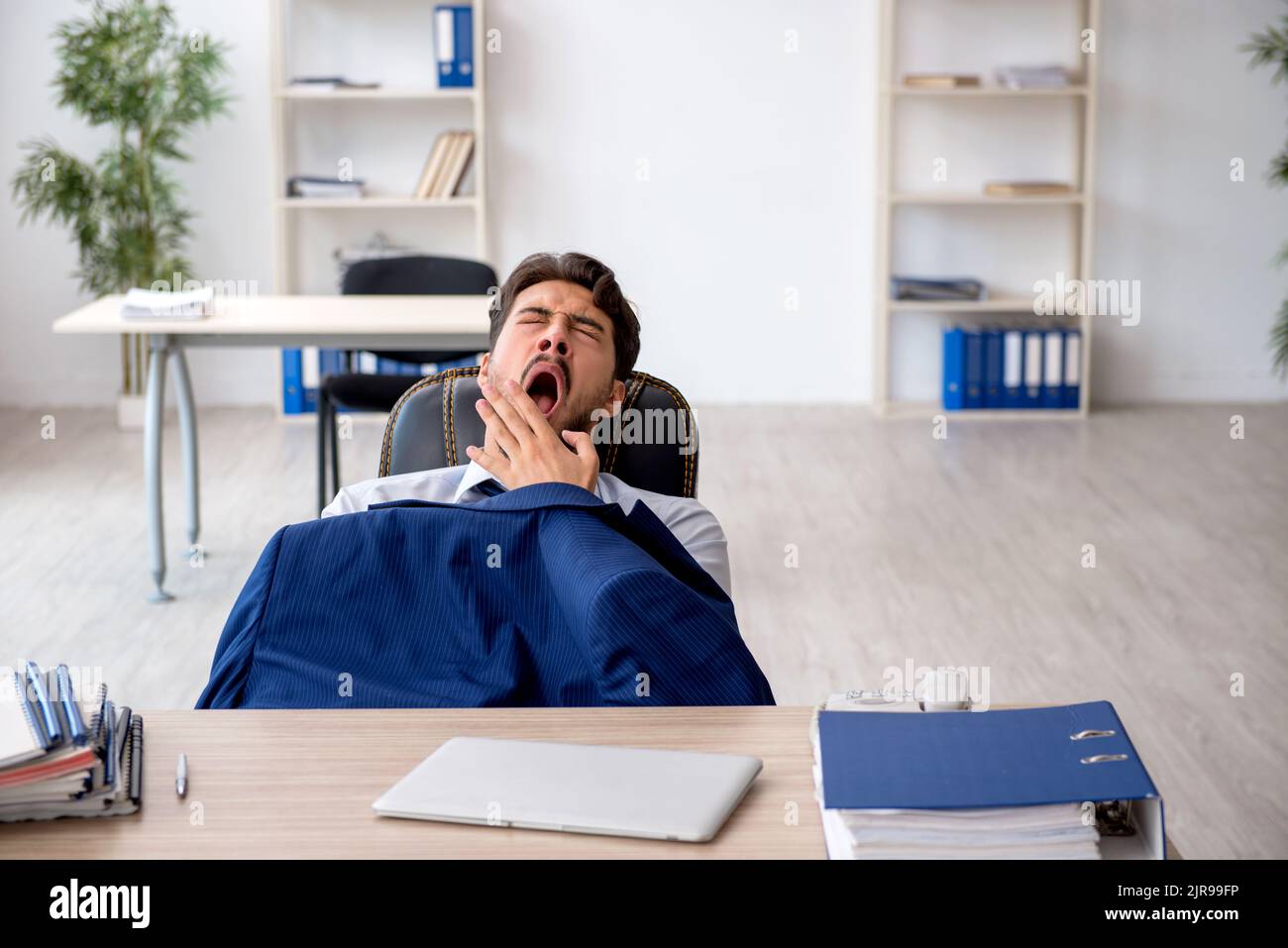 Young businessman employee extremely tired at workplace Stock Photo - Alamy