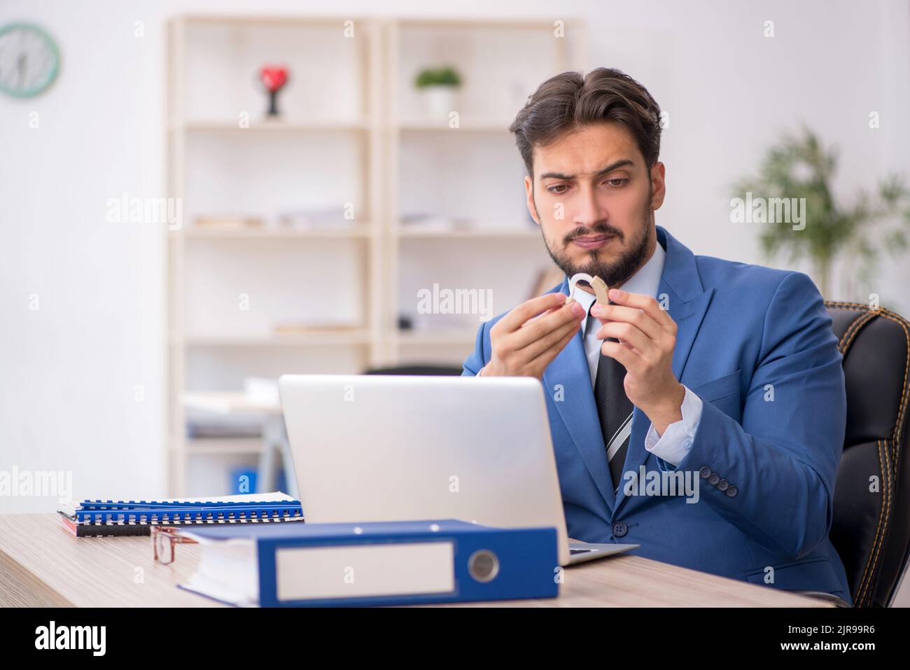 Deaf businessman employee using hearing aid in the office Stock Photo ...
