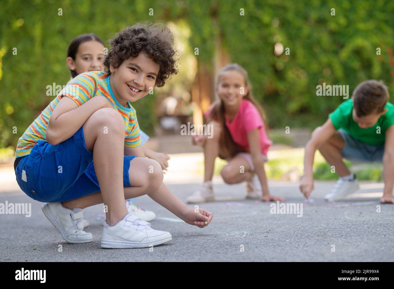 Boy drawing with friends with crayons Stock Photo - Alamy