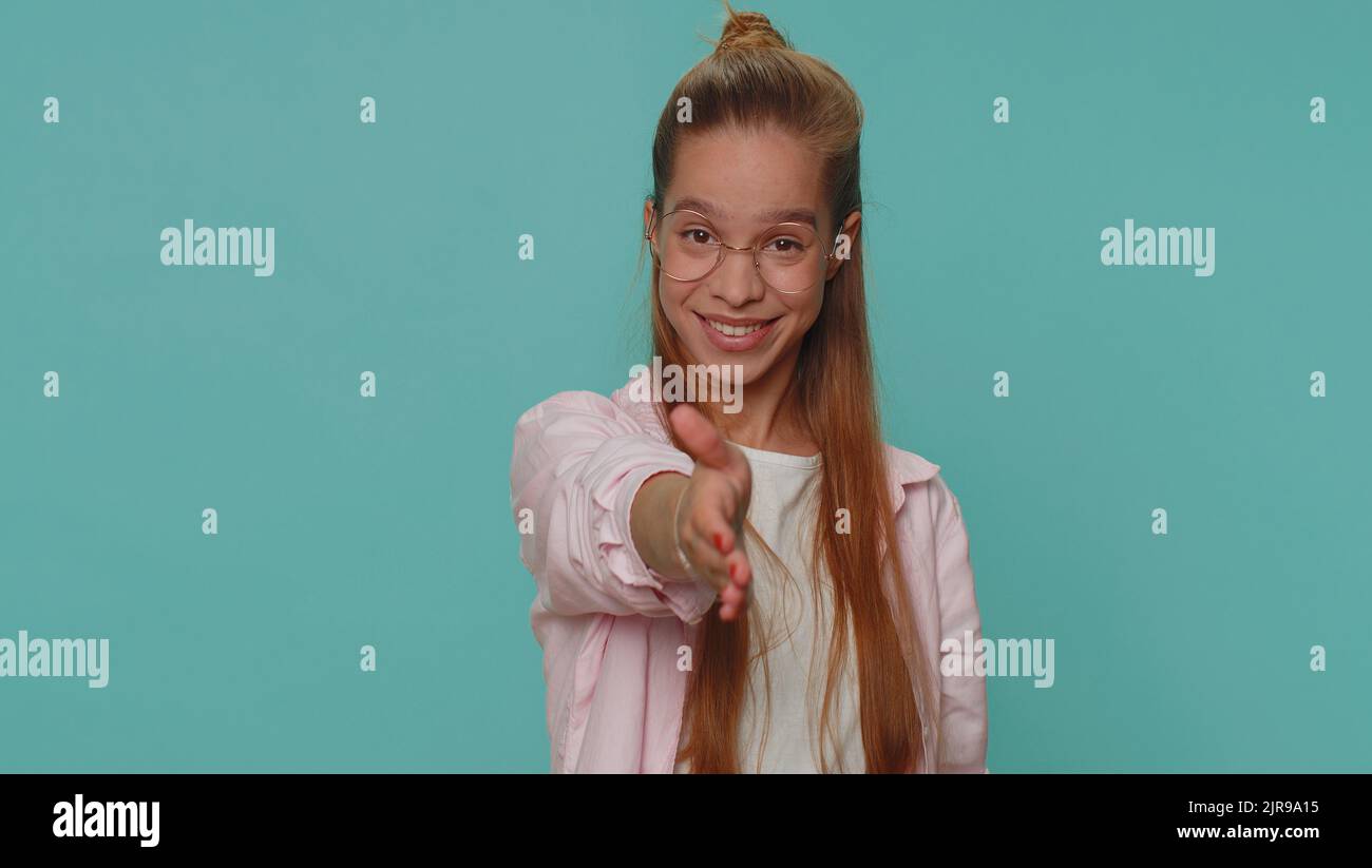 Friendly pretty teenager young girl outstretching hand to camera ...