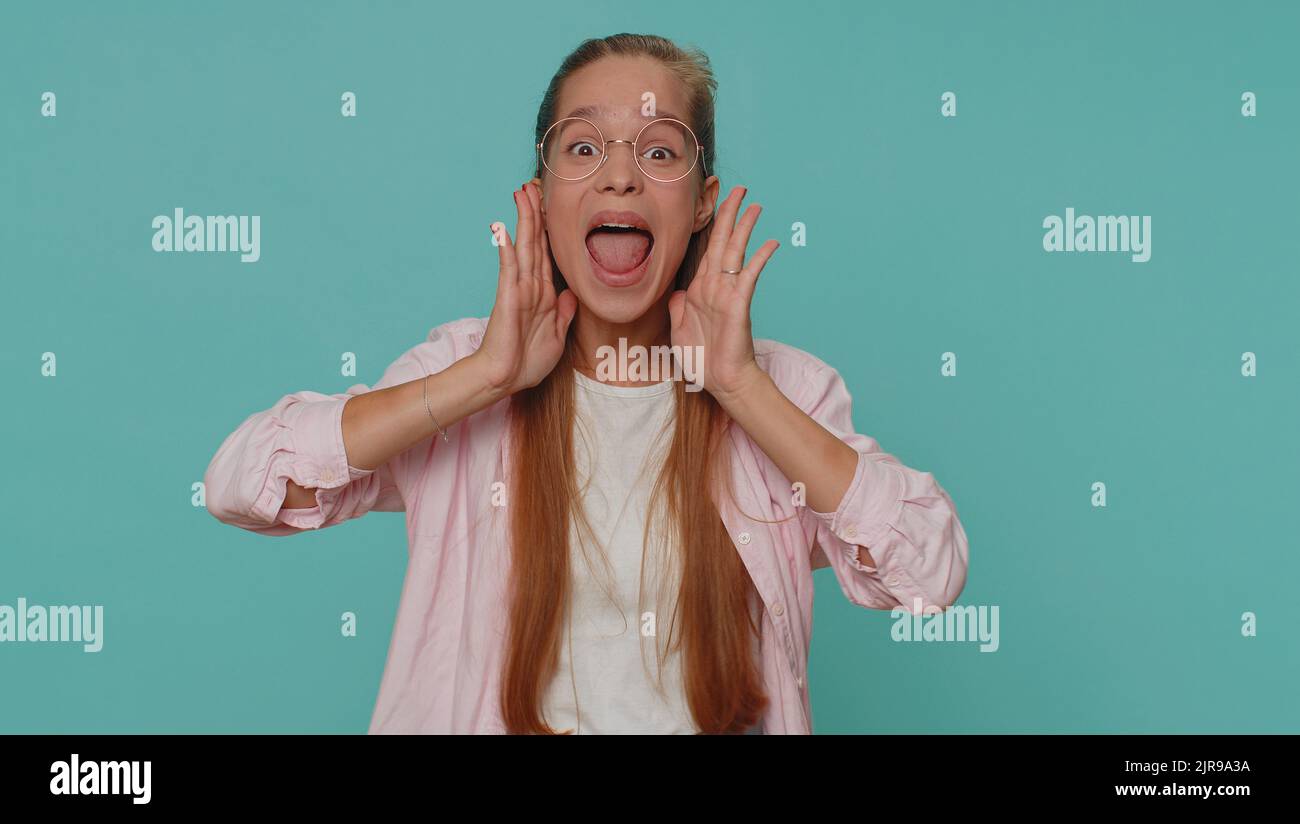 Expressive lovely pretty teenager girl holding hands near mouth loudly ...