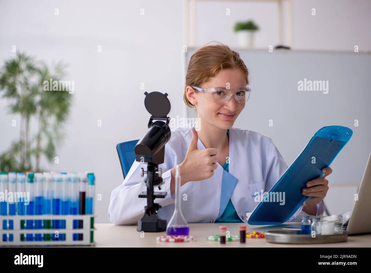Young girl chemist in drugs synthesis concept Stock Photo - Alamy