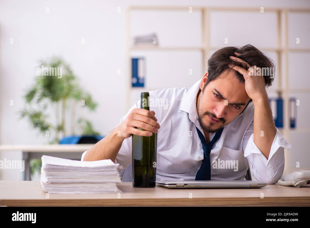 Male alcohol addicted employee sitting in the office Stock Photo - Alamy
