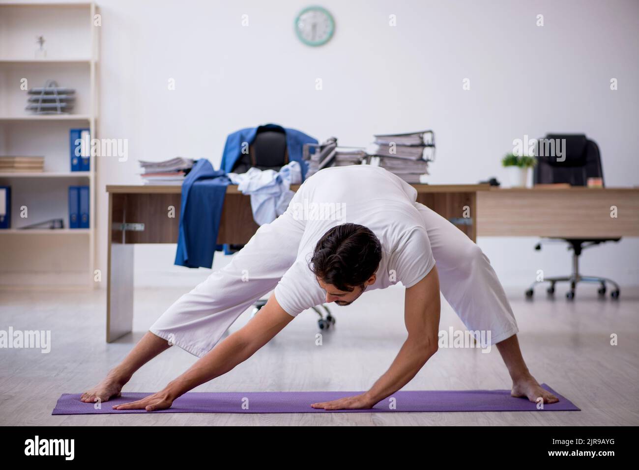 Young businessman employee doing sport exercises at workplace Stock ...