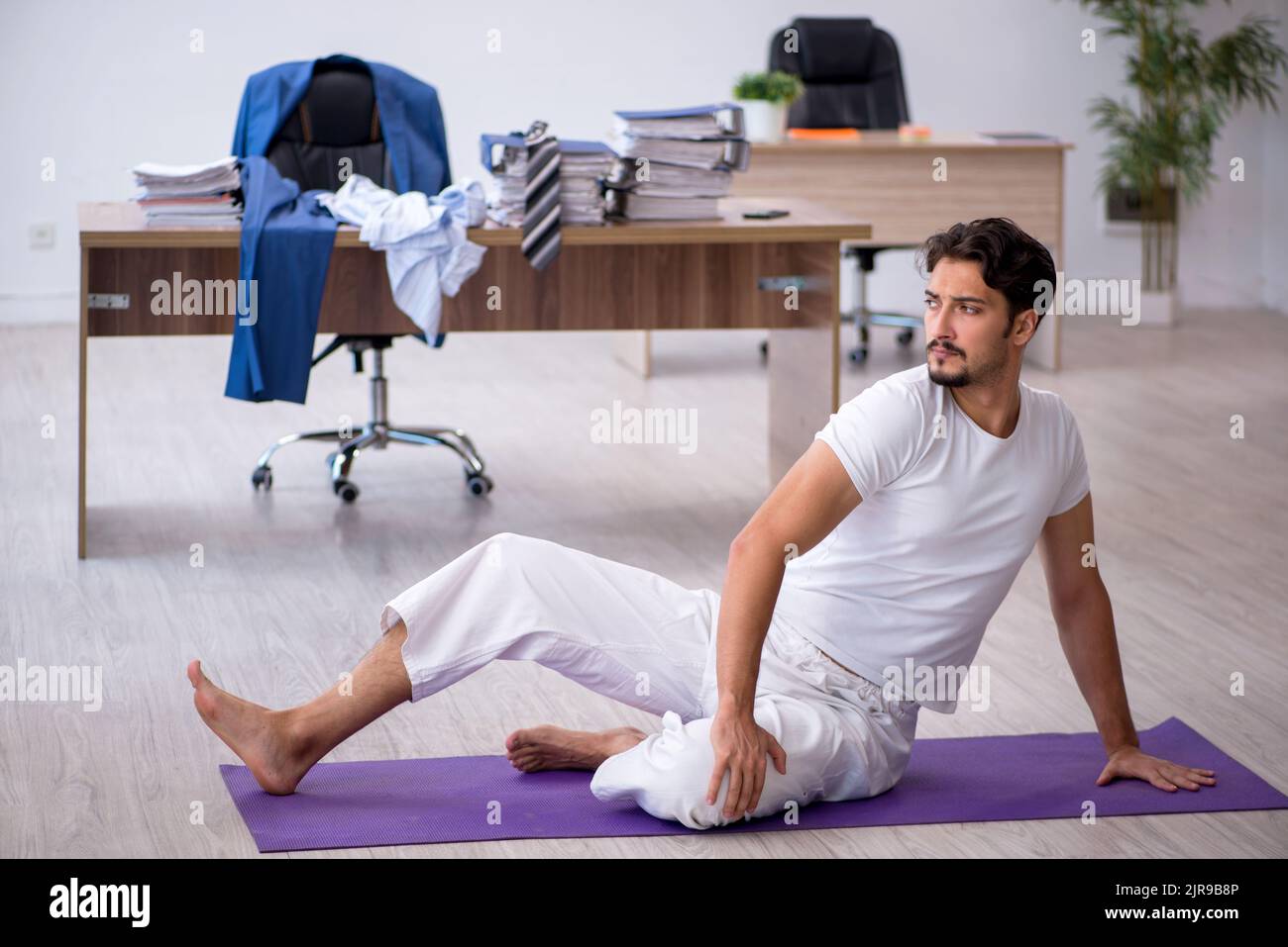 Young businessman employee doing sport exercises at workplace Stock ...