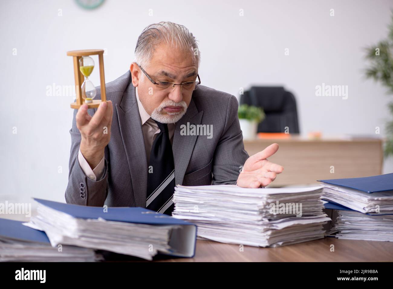 Old male boss in time management concept Stock Photo - Alamy