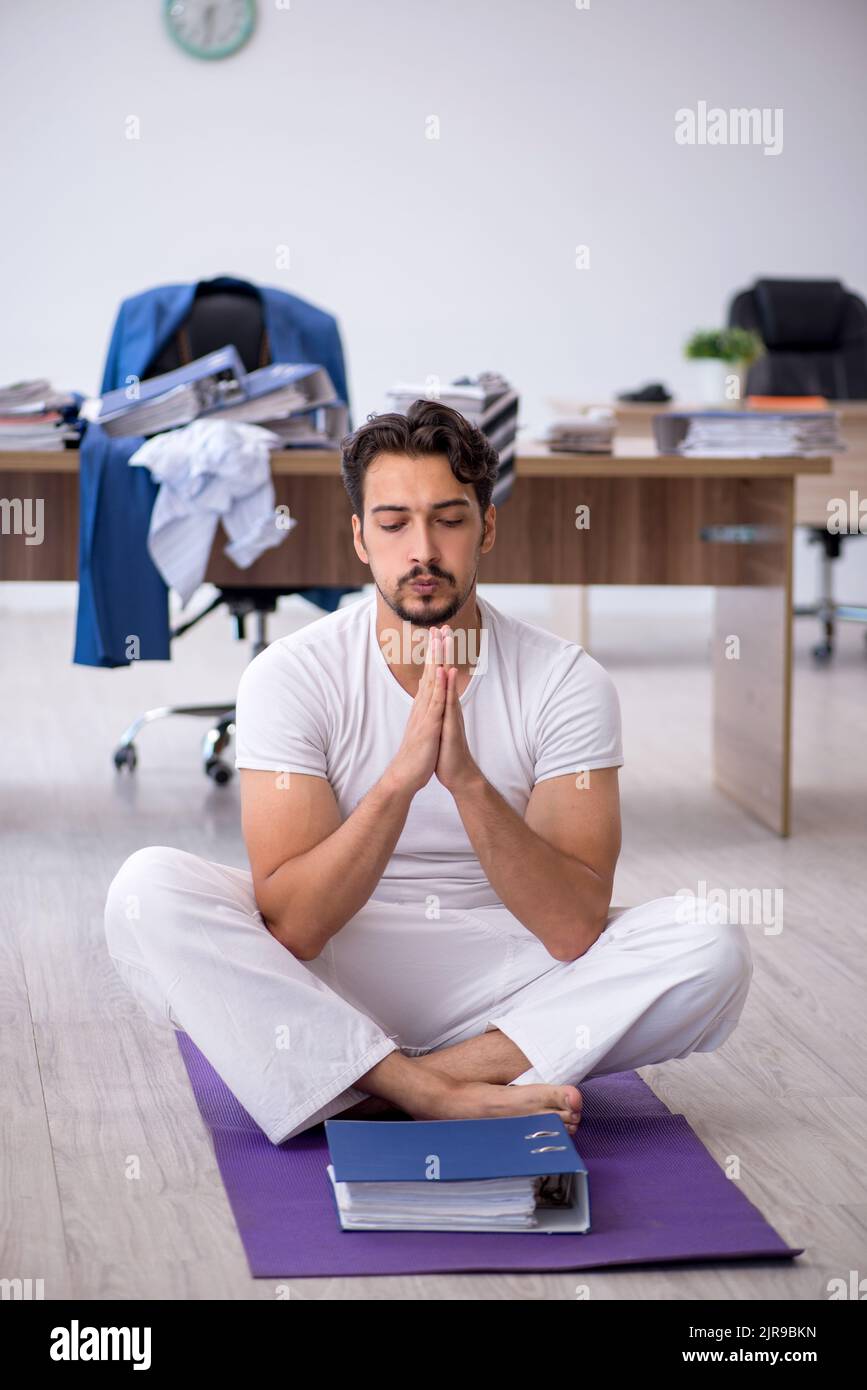 Young businessman employee doing sport exercises at workplace Stock ...