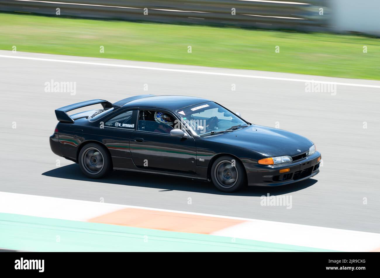 A Japanese black Nissan Silvia S14 Zenki car skidding on a circuit ...