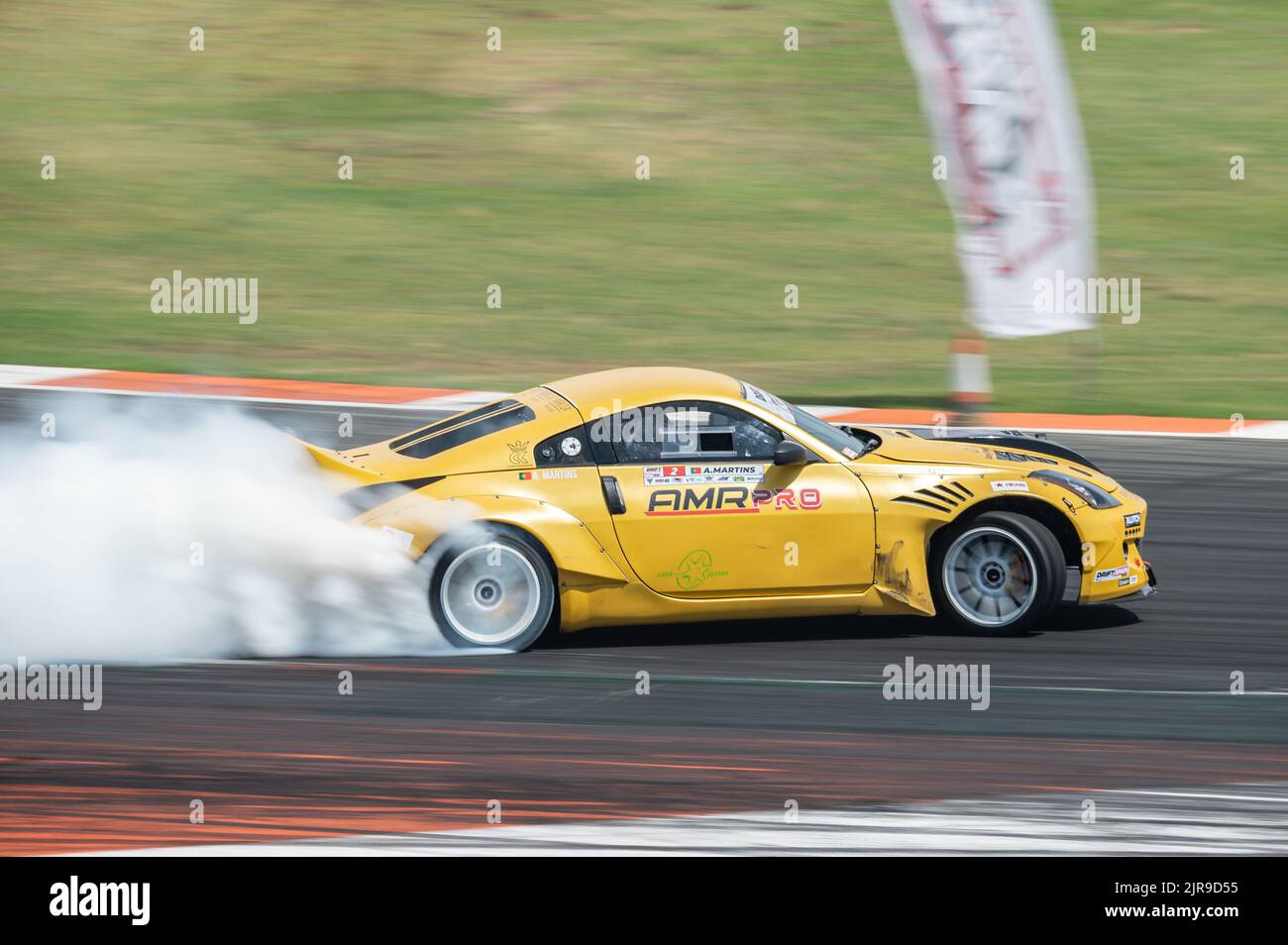 A Japanese yellow Nissan 350Z car skidding on a circuit Stock Photo - Alamy