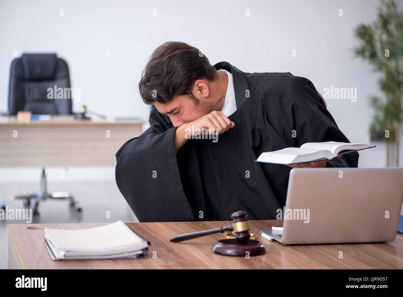 Young judge reading book in the courthouse Stock Photo - Alamy