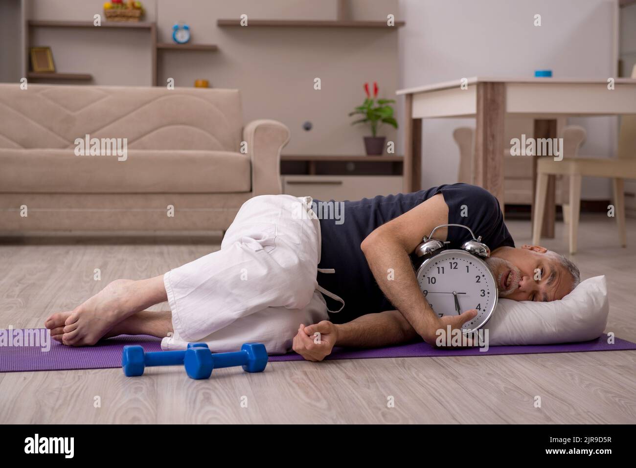 Old man doing sport exercises indoors Stock Photo - Alamy