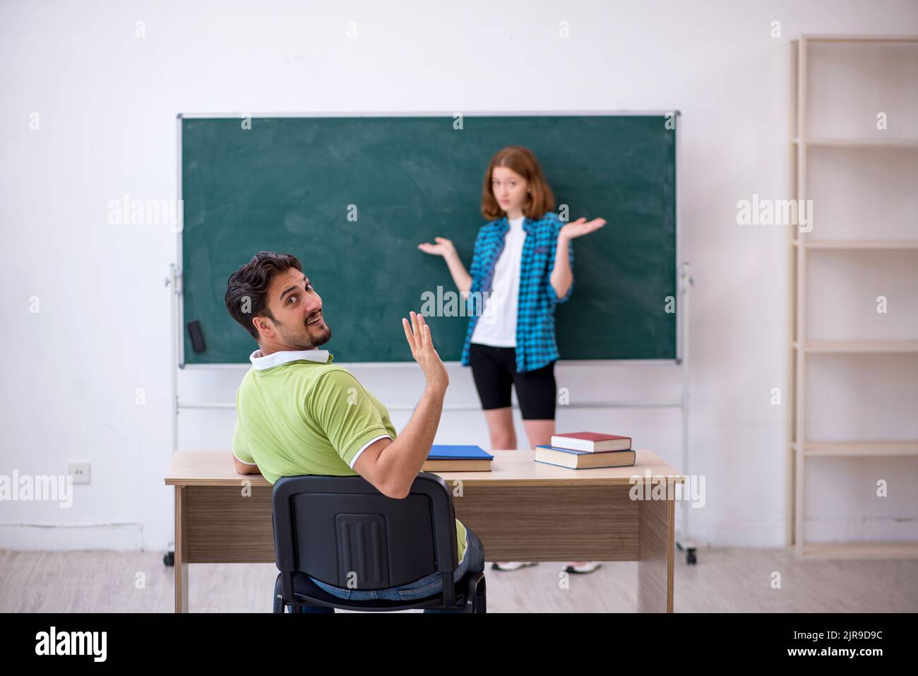 Young teacher teaching student in the classroom Stock Photo - Alamy