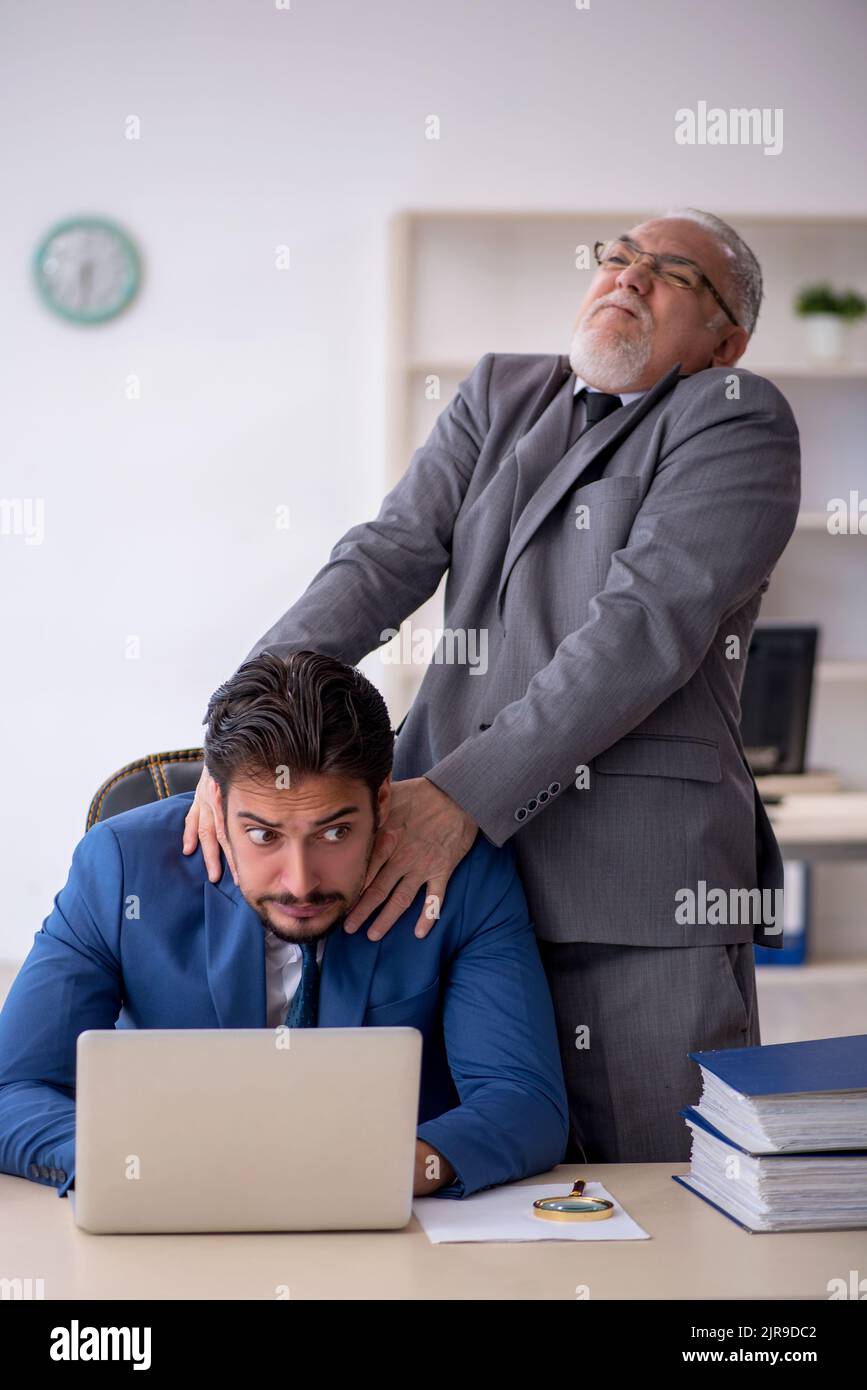 Old boss and young employee working at workplace Stock Photo - Alamy