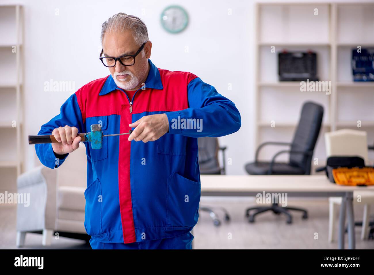Old repairman working at workshop Stock Photo - Alamy