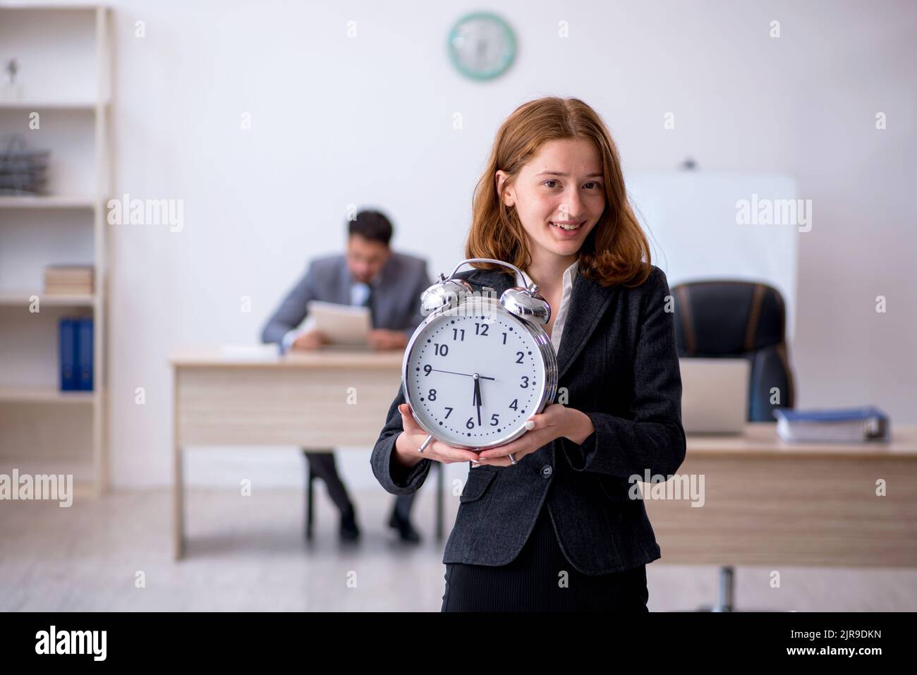 Two colleagues working in the workplace in time management concept ...