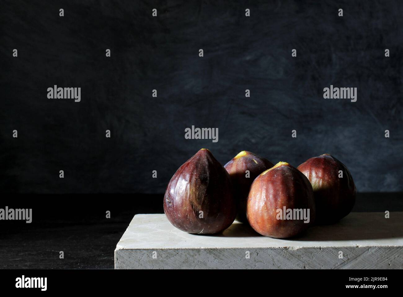 The fresh ripe figs on white marble against black background Stock ...