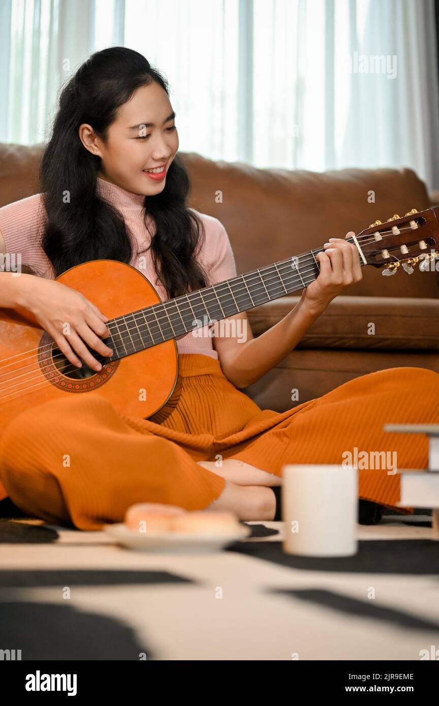 Portrait, Attractive hipster young Asian female relaxes in the living ...