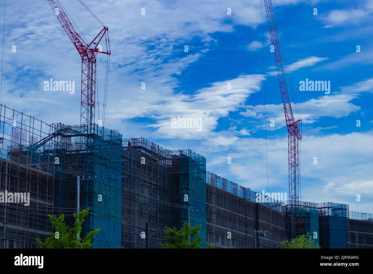Cranes at the under construction daytime long shot Stock Photo - Alamy