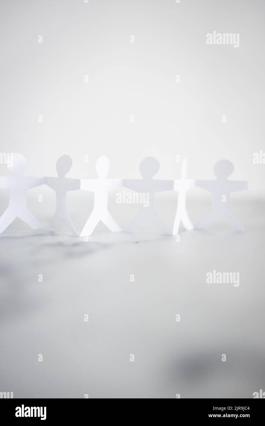 manpower and teamwork conceptual image, paper people chain with text on white marble background ...