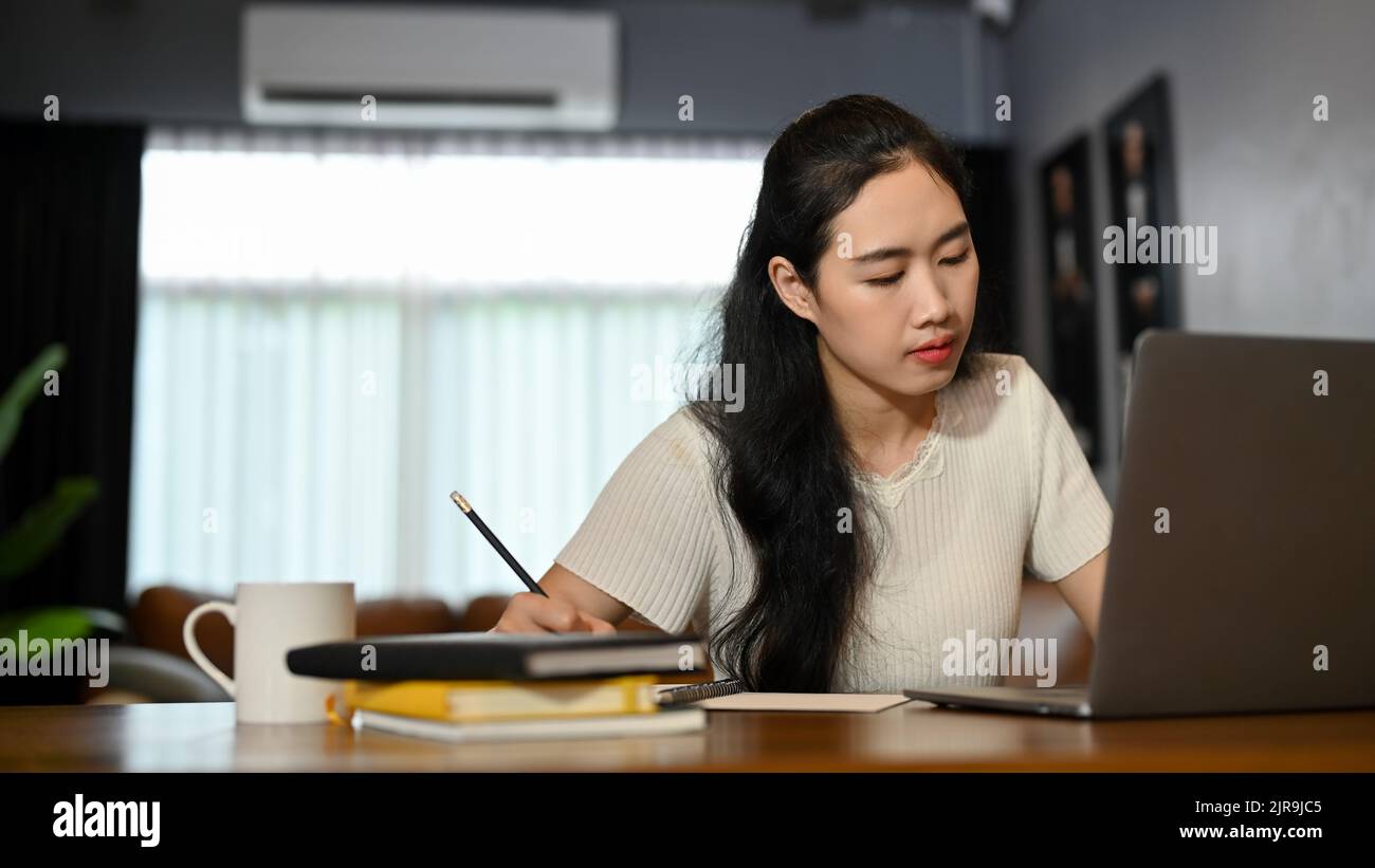 Smart young Asian female university student focusing on her online ...