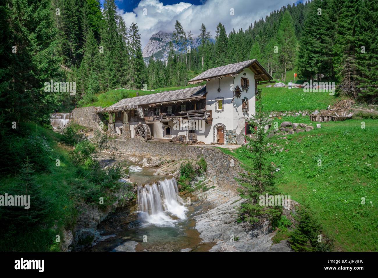 A windmill in the italian mountains with a water stream Stock Photo - Alamy