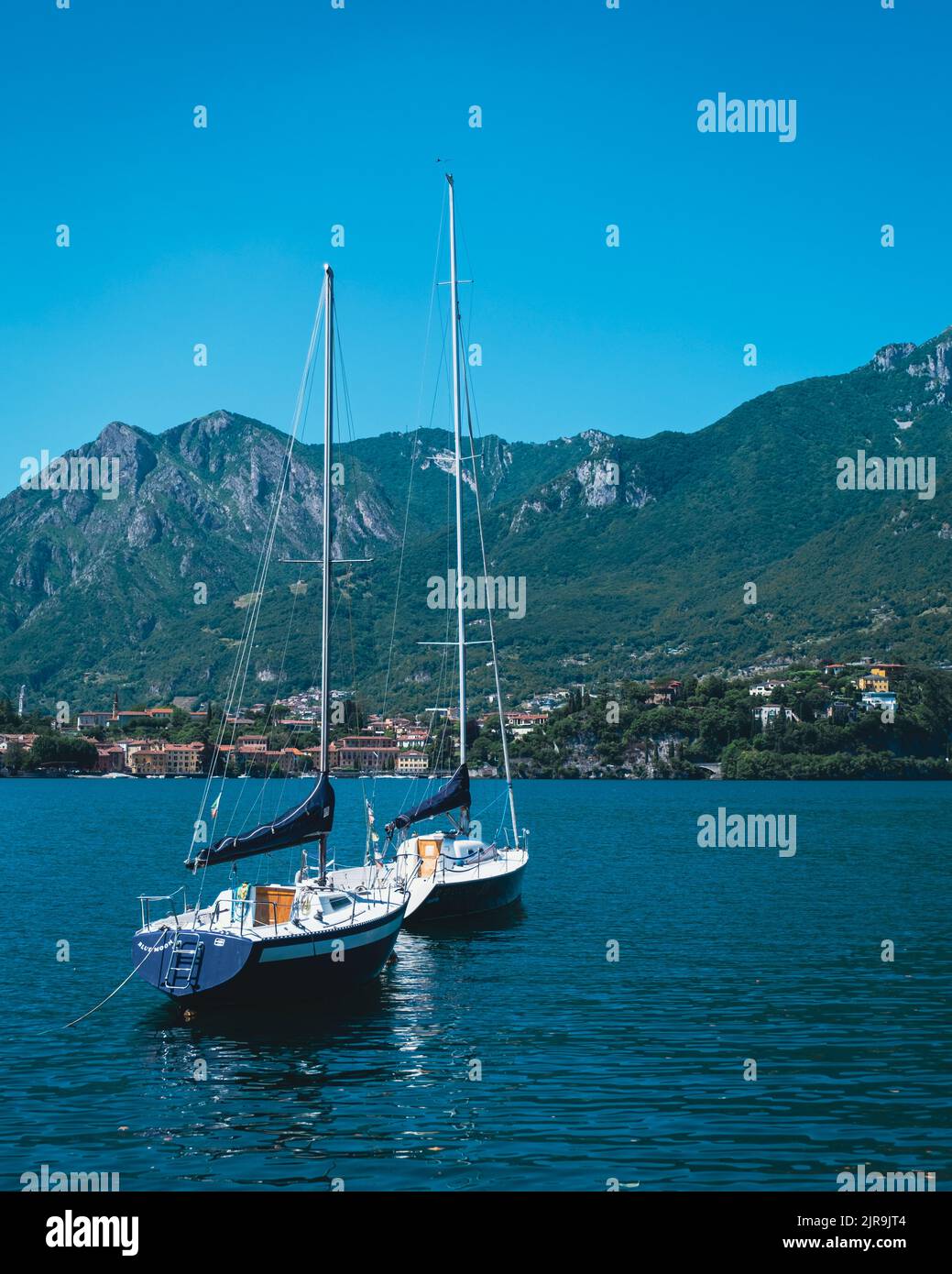 Sail boats in the lake Como on a sunny day with mountains in the ...