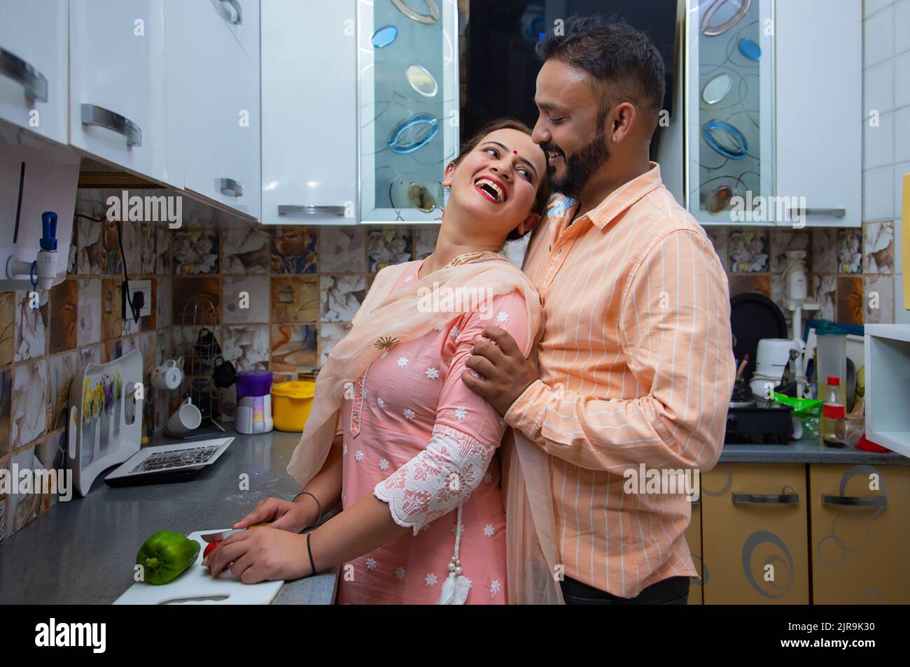 Portrait of young romantic couple standing together in the kitchen ...