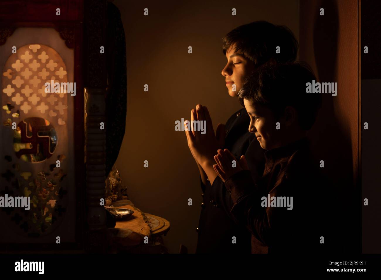 Portrait of two brothers praying together to God with folded hands ...