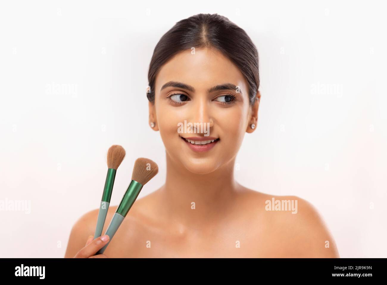 Close-up portrait of a beautiful woman applying make-up on face Stock ...