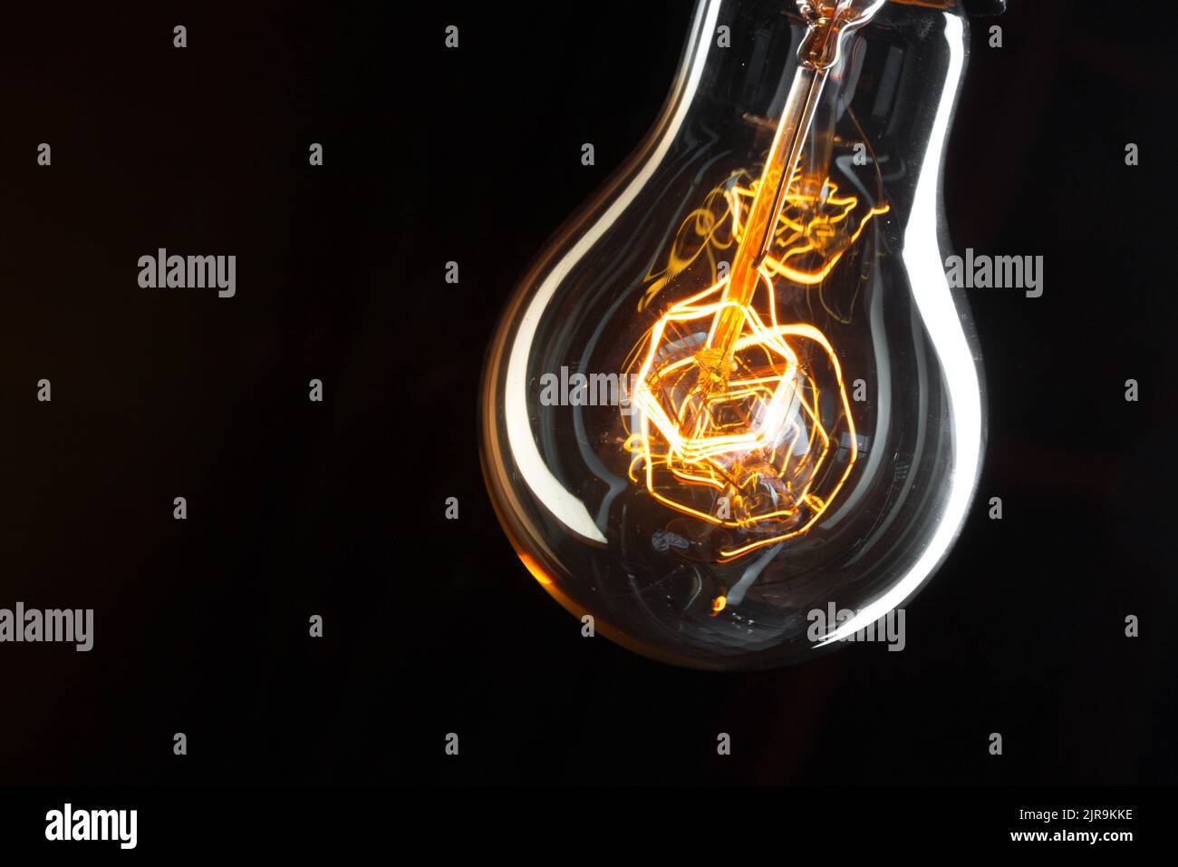 A classic Edison light bulb on dark background with space for text ...