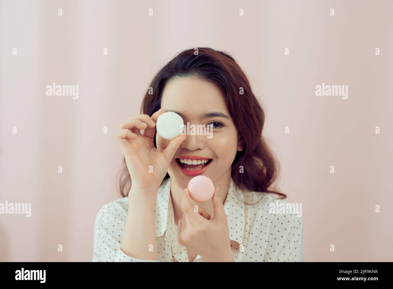 Young woman over isolated pink background holding colorful French ...