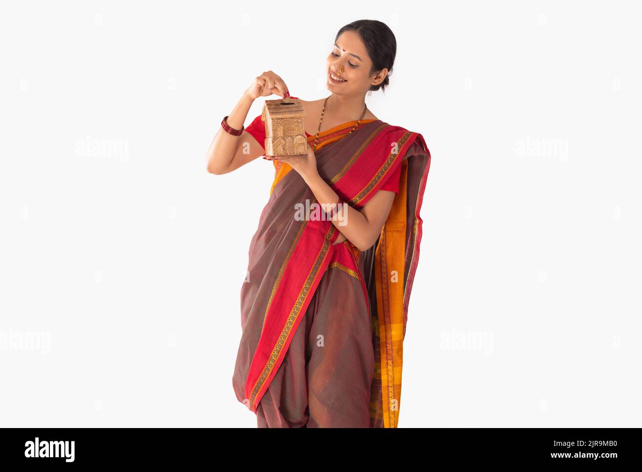 Portrait of a Maharashtrian woman putting coin into money box Stock ...