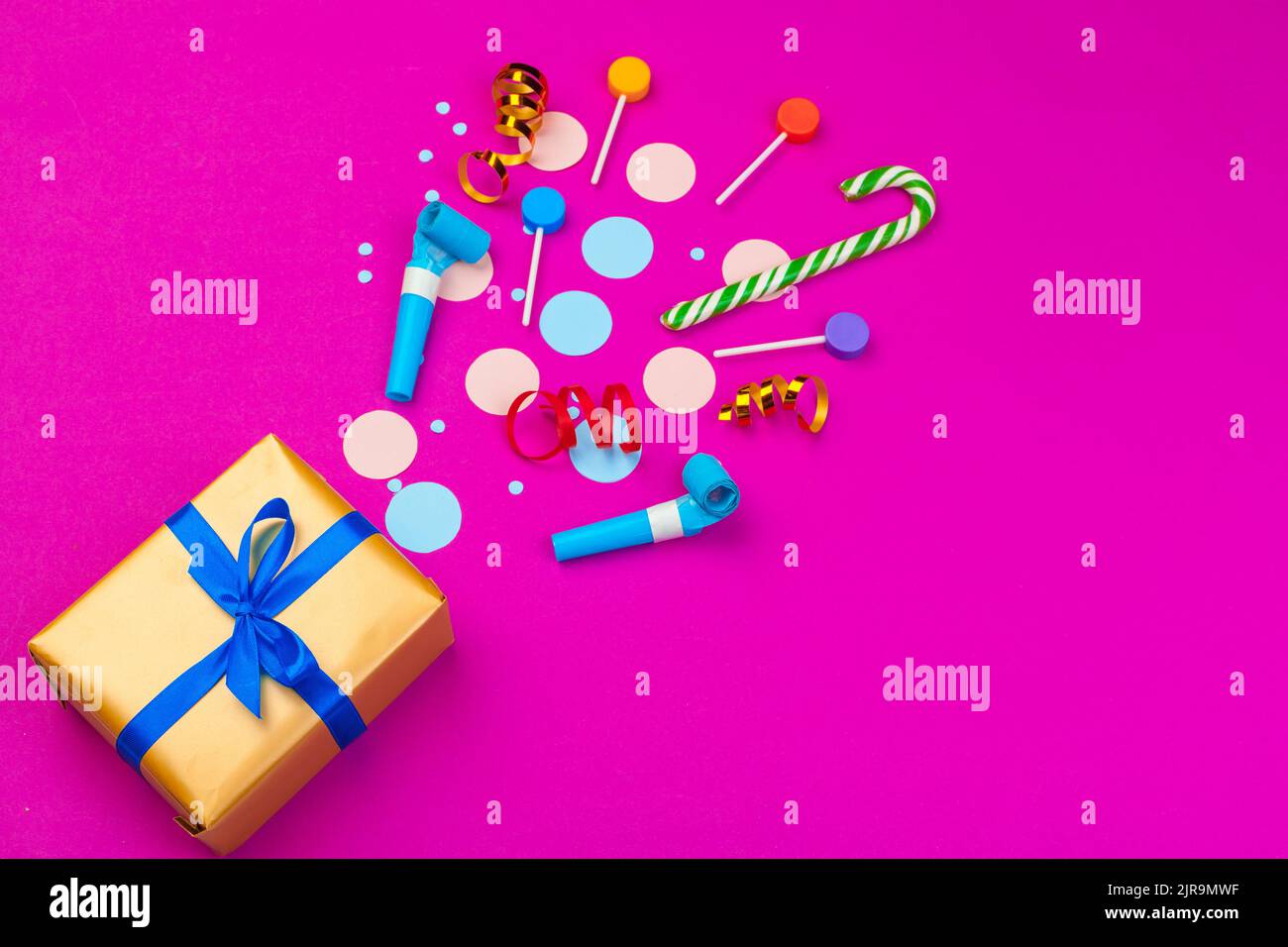 Box with splashed confetti of ribbon, dudes and other festive ...