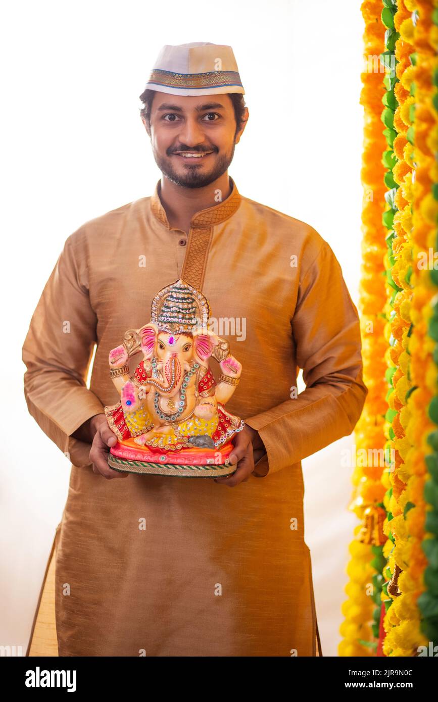 Portrait of a Maharashtrian man carrying statue of Lord Ganesh Stock ...