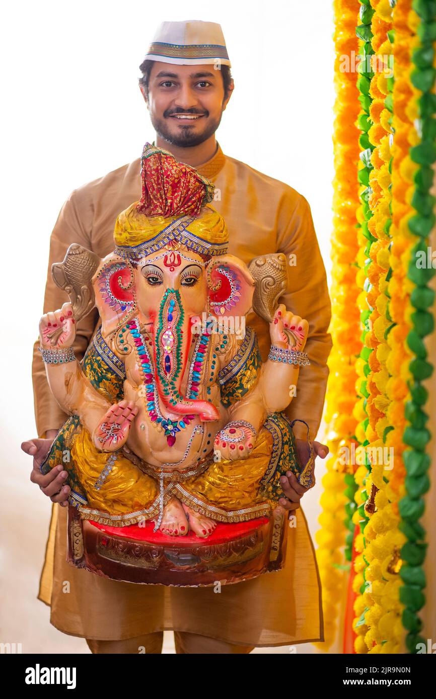 Portrait of a Maharashtrian man carrying statue of Lord Ganesh Stock ...