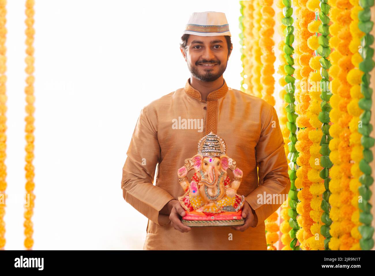 Portrait of a Maharashtrian man carrying statue of Lord Ganesh Stock ...