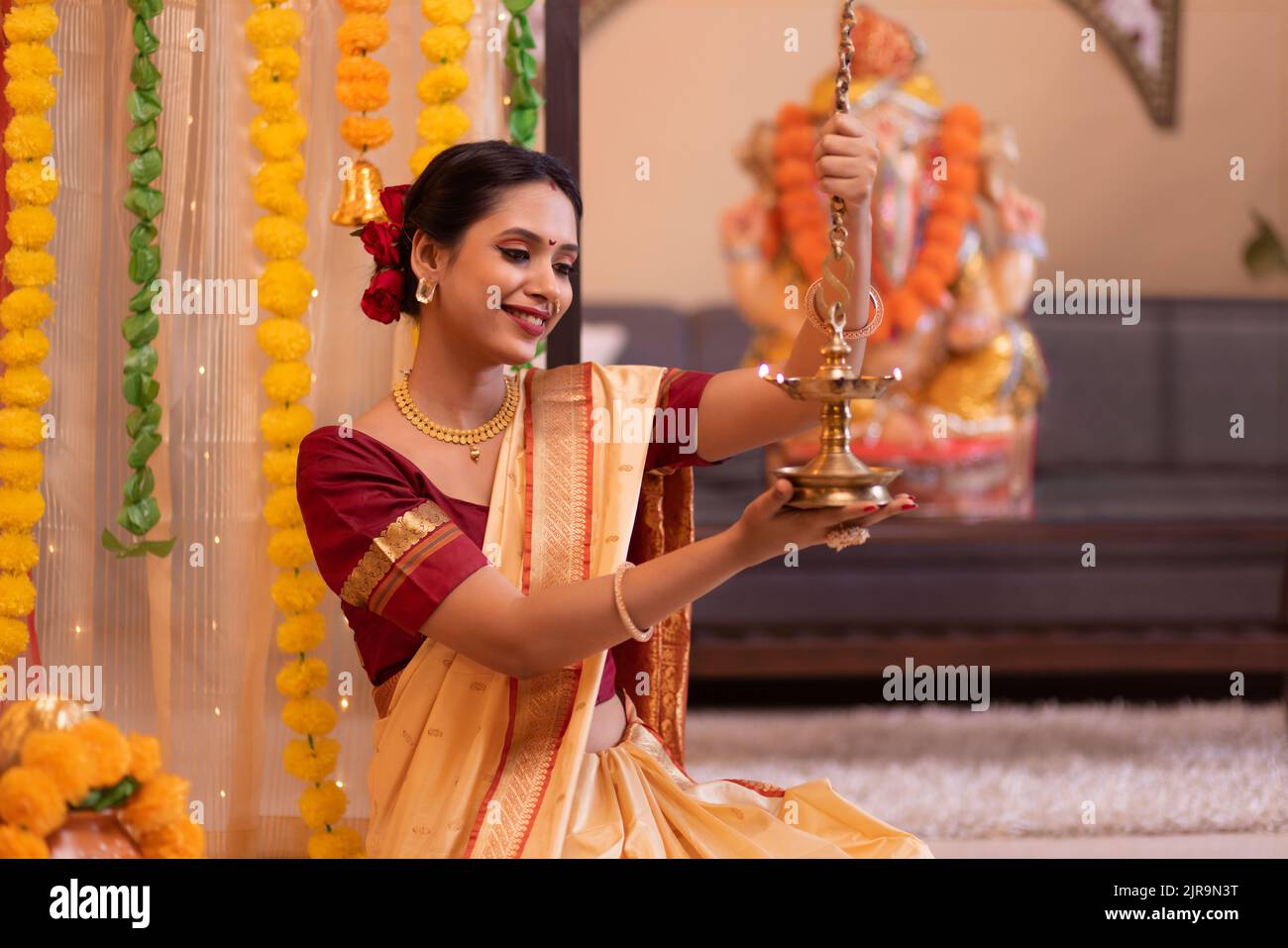 Portrait of Maharashtrian woman in traditional dress holding oil lamp ...