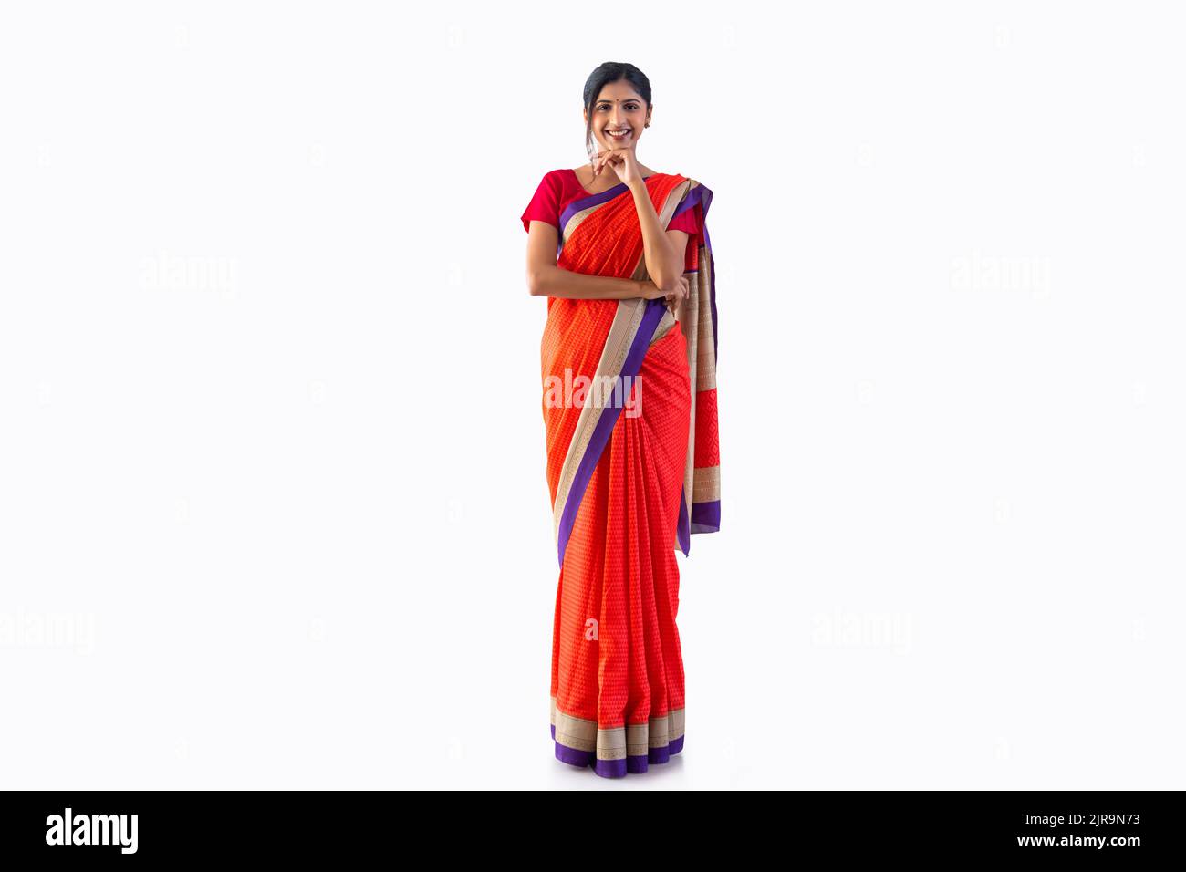 Beautiful Indian woman in sari gesturing with hand on chin against ...