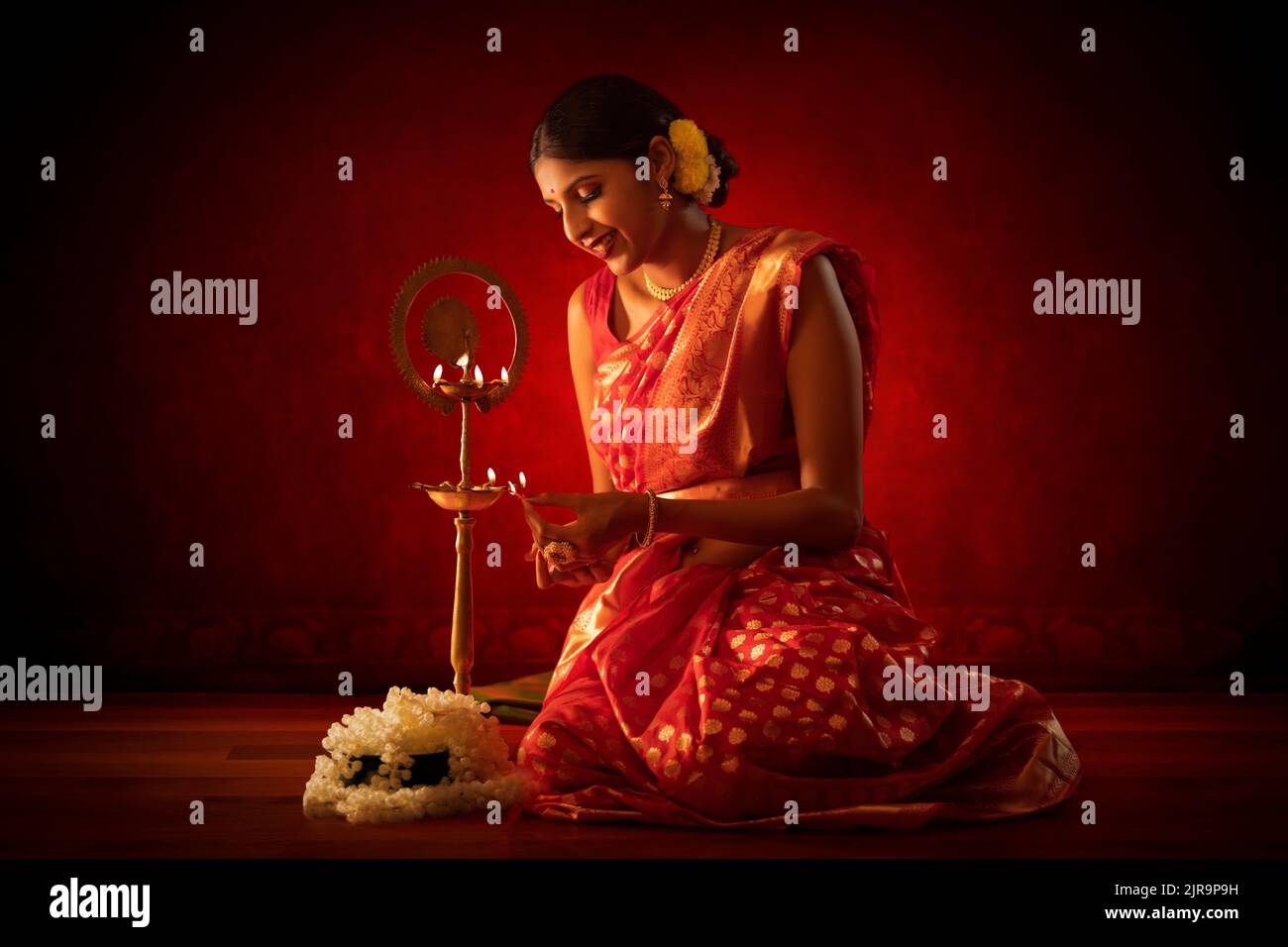 Indian woman lighting oil lamp hi-res stock photography and images - Alamy